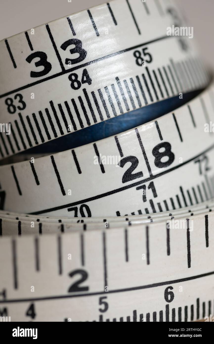 Curled up tape measure in inches and centimetres Stock Photo - Alamy