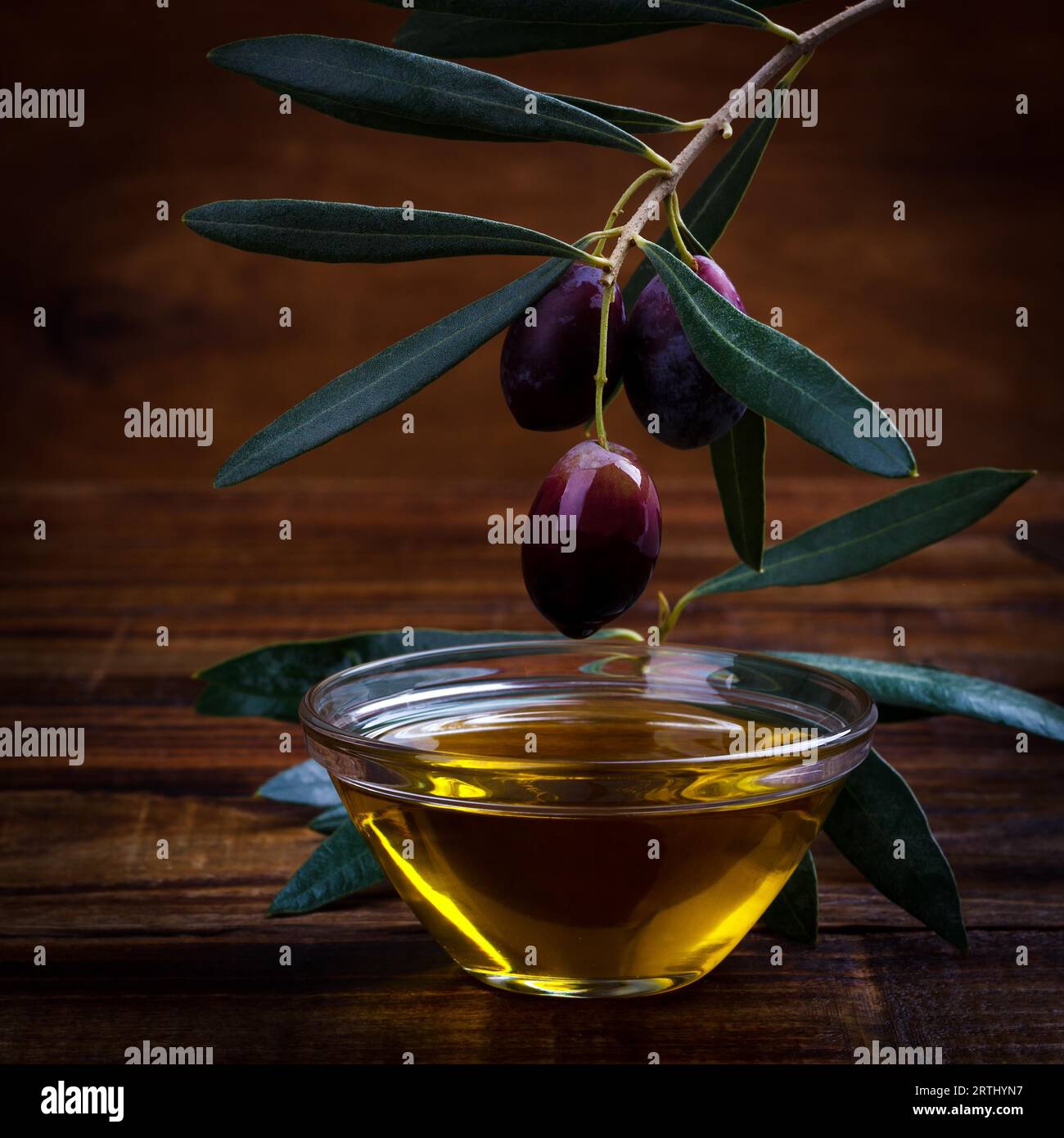 Bowl of olive oil and purple olives on dark wooden background Stock ...