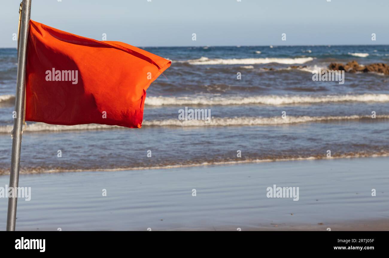Red flag waving on a beach with ocean currents Stock Photo - Alamy