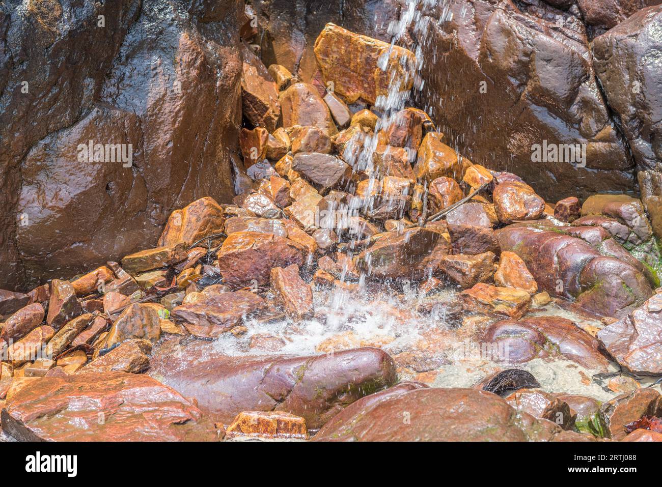 Small waterfall among rocks and stones in moss by the beach Stock Photo ...