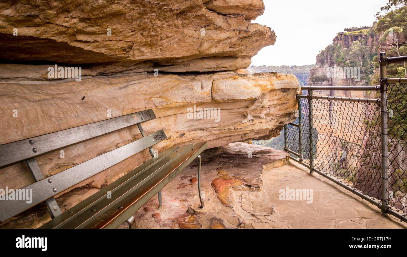 A bench is inviting tired hikers to have a rest below beautiful rock ...
