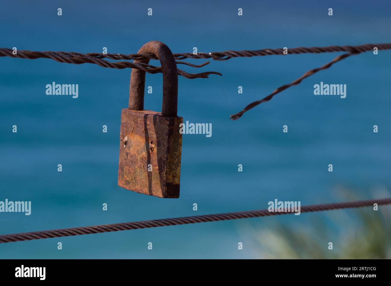 Closed padlock on cut iron rope represents insecurity Stock Photo - Alamy