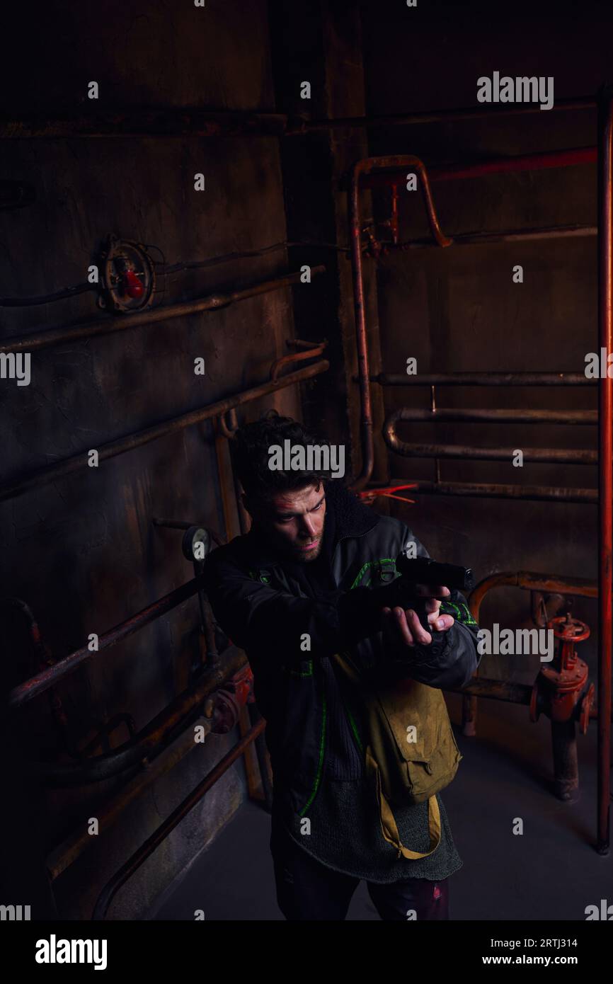 high angle view of concentrated man aiming with gun in dangerous post ...