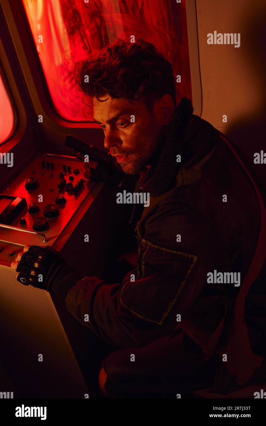 tense man with gun thinking near dashboard of abandoned post-disaster ...