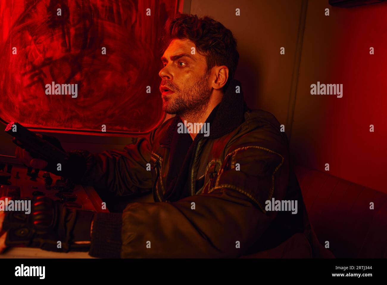 tense man with gun sitting in dirty carriage in abandoned subway in red ...