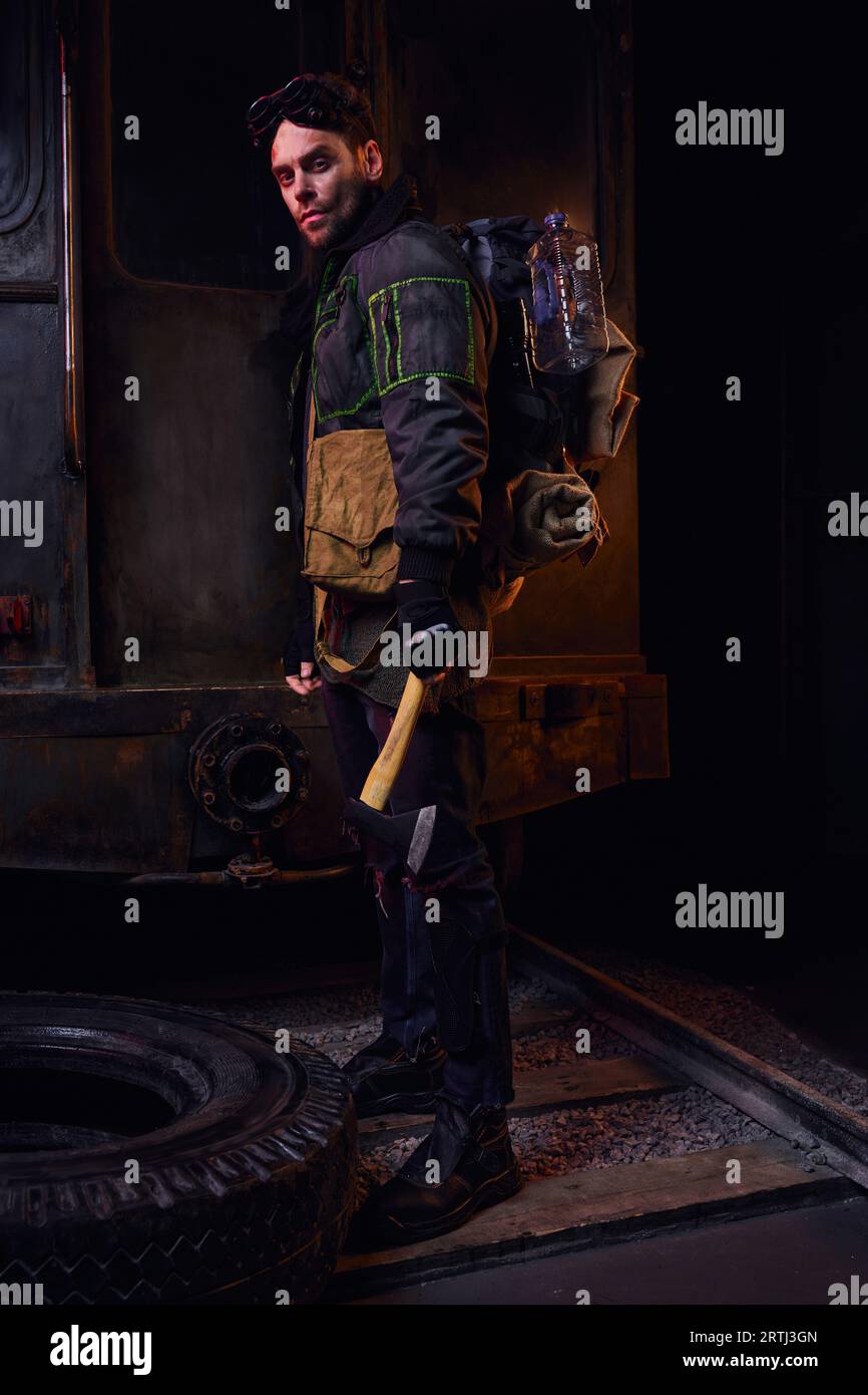 post-apocalyptic survivor with backpack, water bottle and axe looking ...