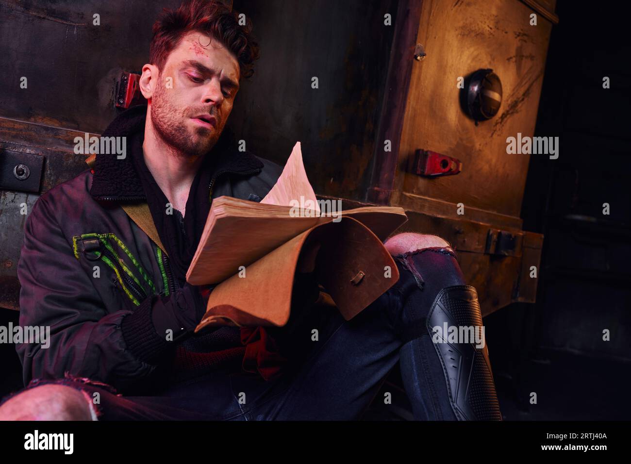 unshaven injured man sitting in abandoned post-apocalyptic subway and ...