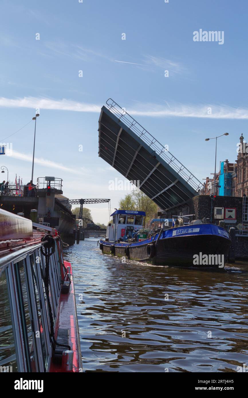 Ship passing under an open drawbridge in Amsterdam, Netherlands in ...