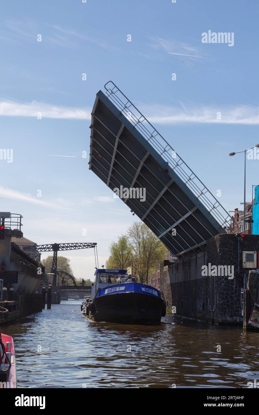 Ship passing under an open drawbridge in Amsterdam, Netherlands in ...