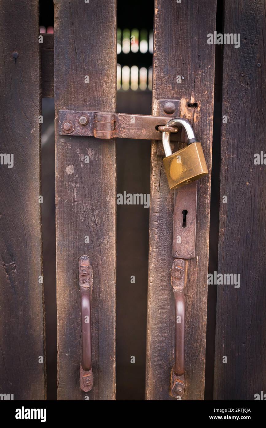 Close up view of a padlock with an old metal hasp and staple on an old ...