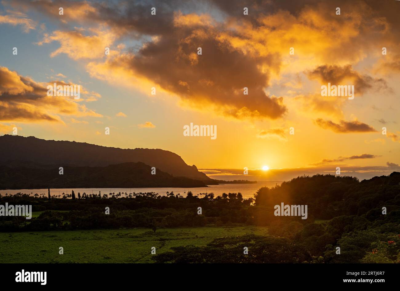 Sun slowly setting over the ocean of Hanalei Bay on the north coast of ...