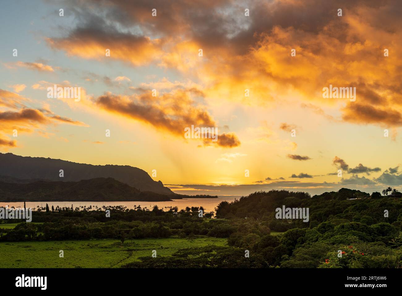 Sun slowly setting over the ocean of Hanalei Bay on the north coast of ...
