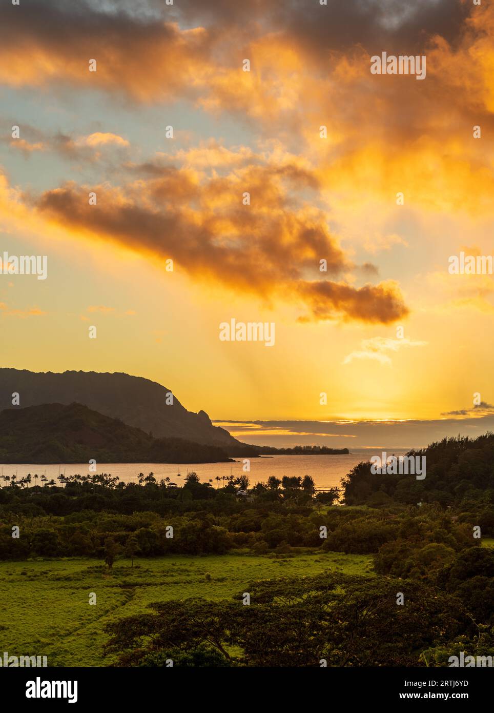 Sun slowly setting over the ocean of Hanalei Bay on the north coast of ...
