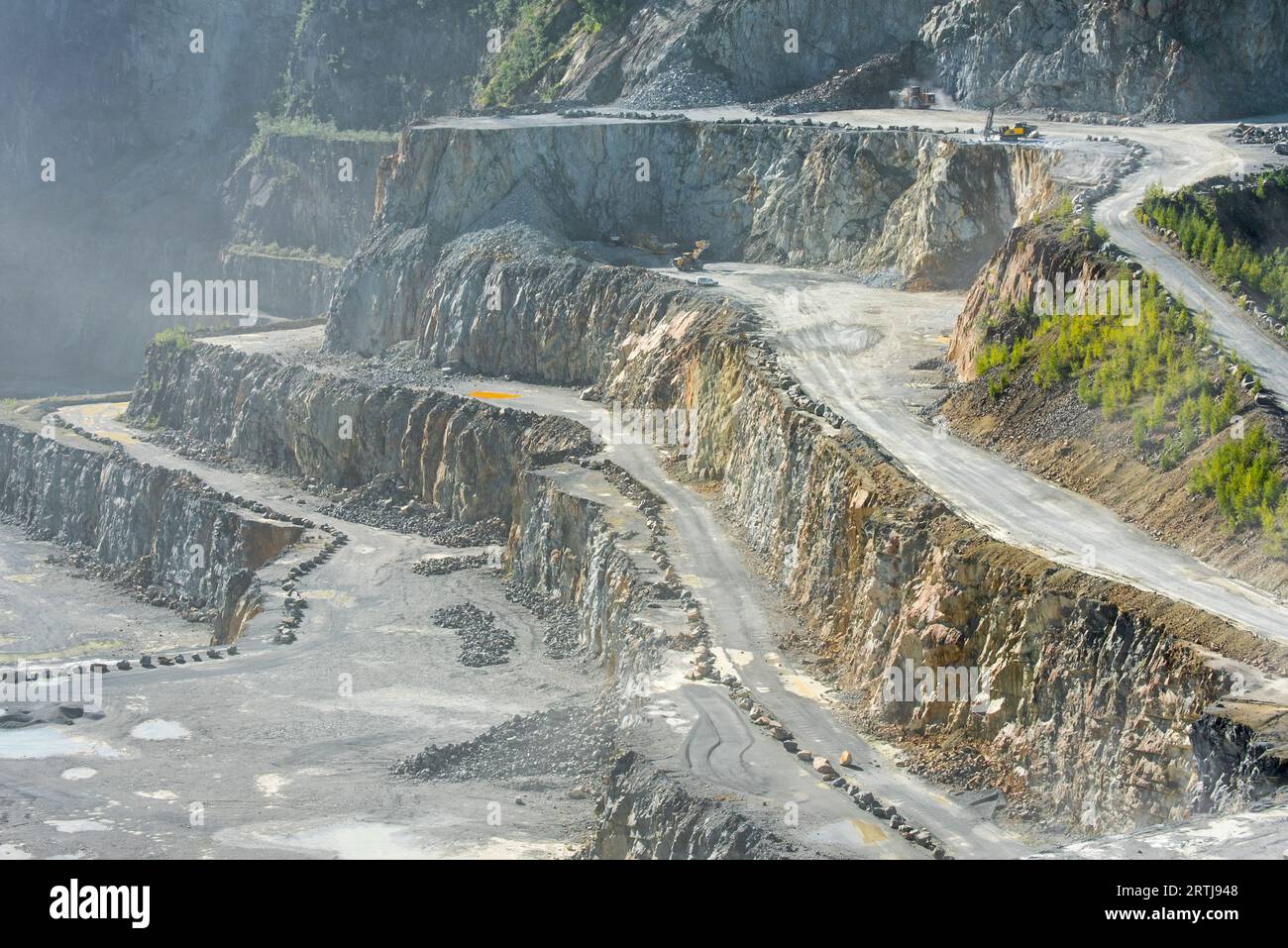 Heavy machines working in dusty porphyry quarry, open-pit mine for the ...