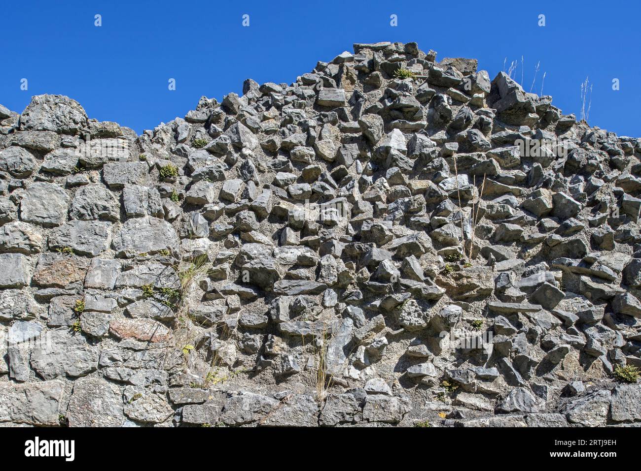 Thick stone wall of medieval castle showing two types of masonry ...