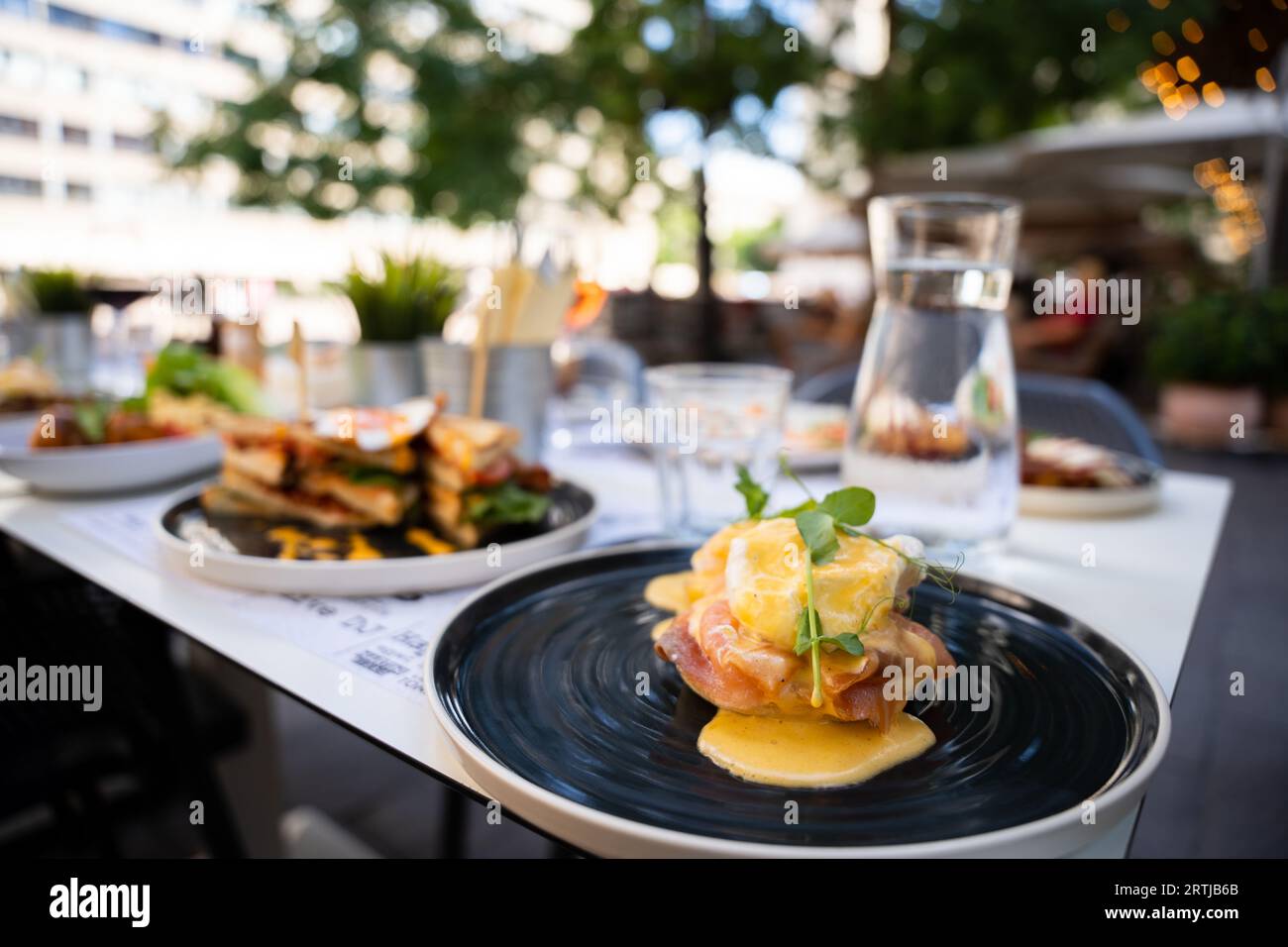 Eggs Benedict with ham and ham outside at a brunch Stock Photo - Alamy