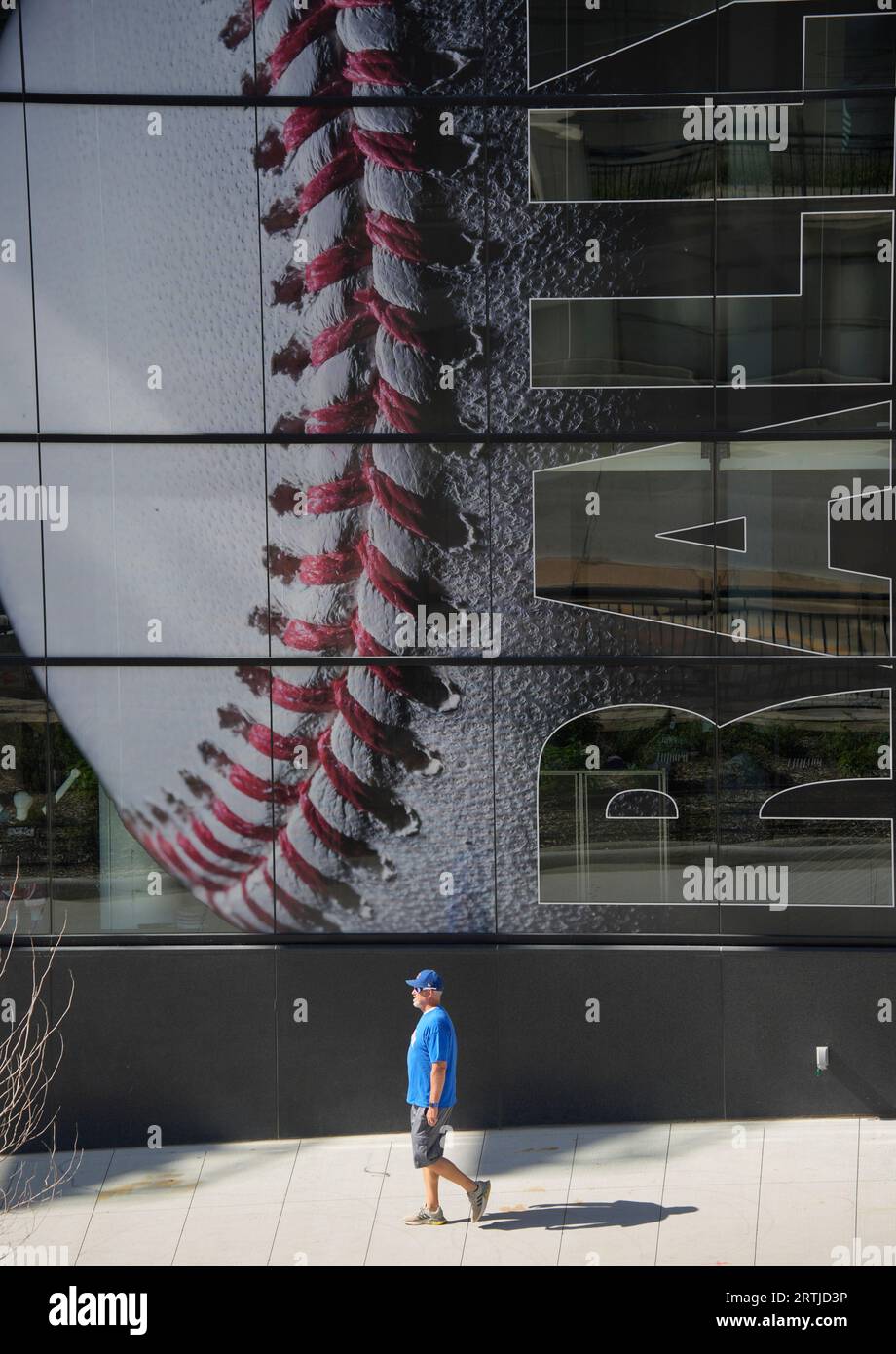 A lone Chicago Cubs fan walks past a baseball motif in a window of the ...