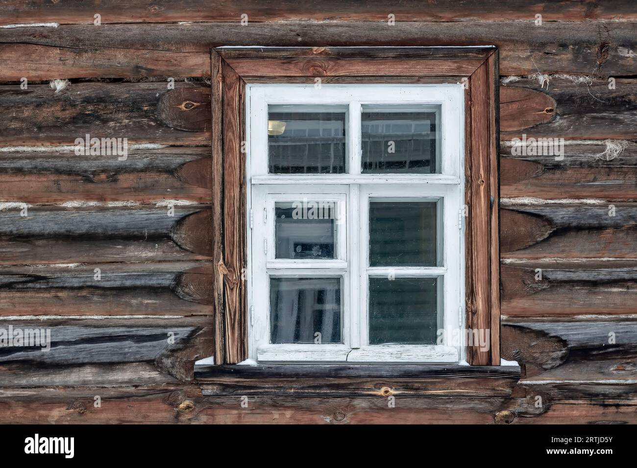 Old rectangular window with a white frame in an old log house. From the ...