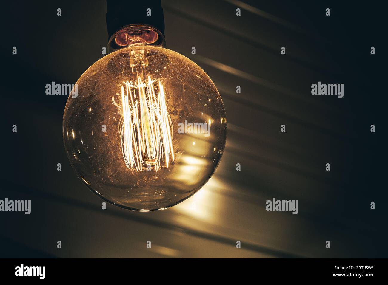 From below several light bulbs hanging under the ceiling in a dark room ...