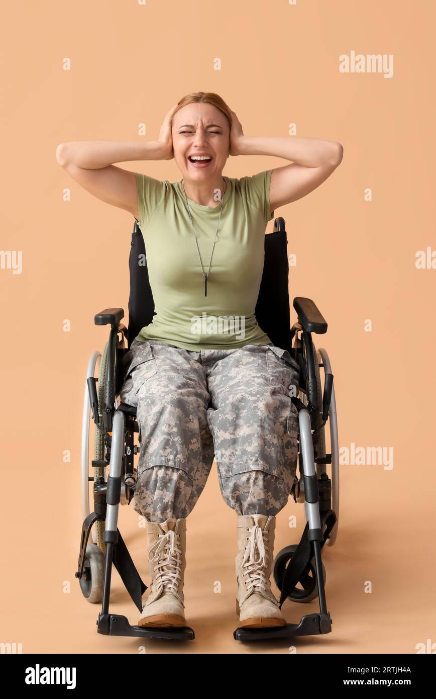 Female soldier in wheelchair with PTSD on beige background Stock Photo ...