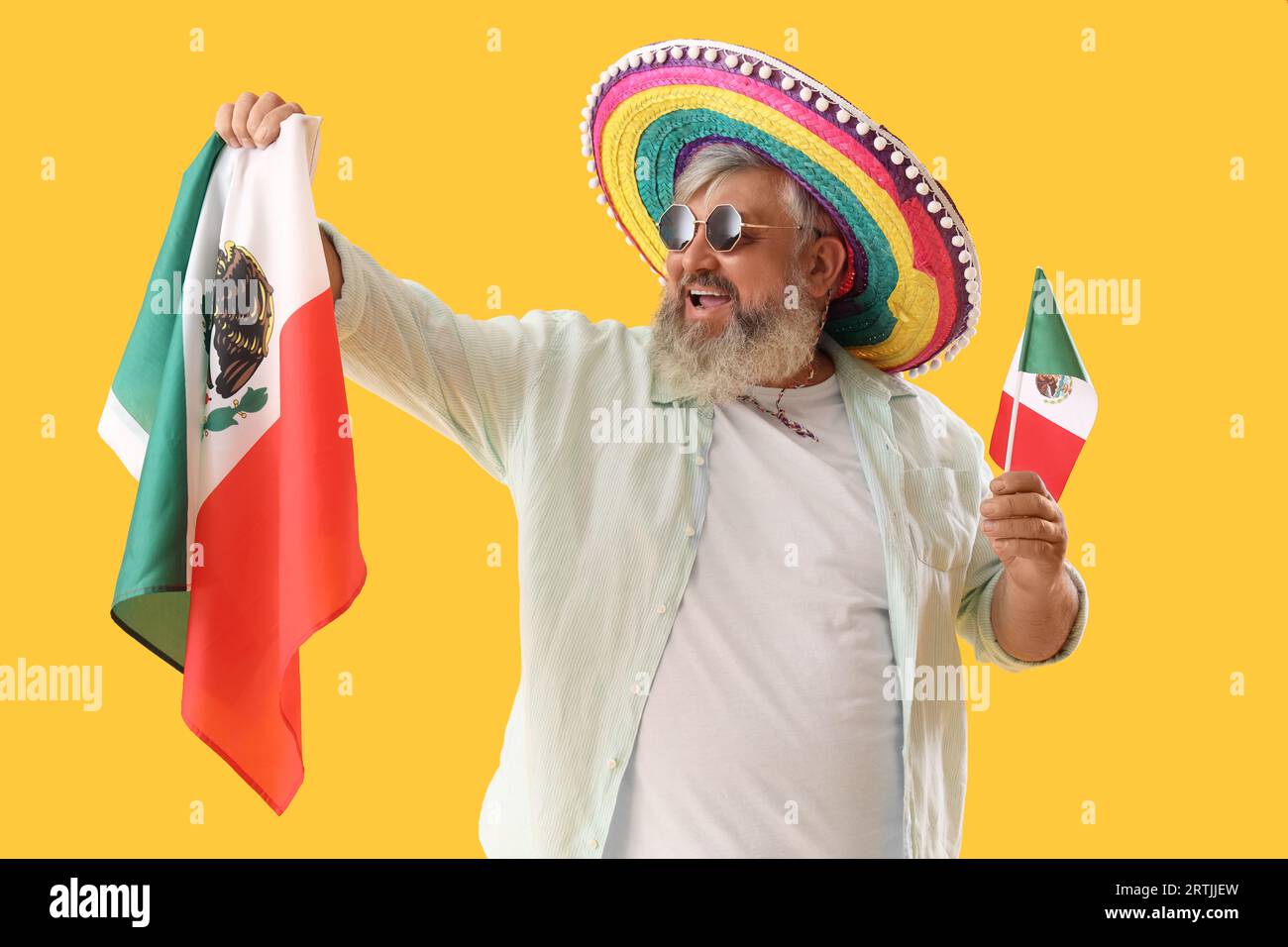 Mature man in sombrero hat with Mexican flags on yellow background ...