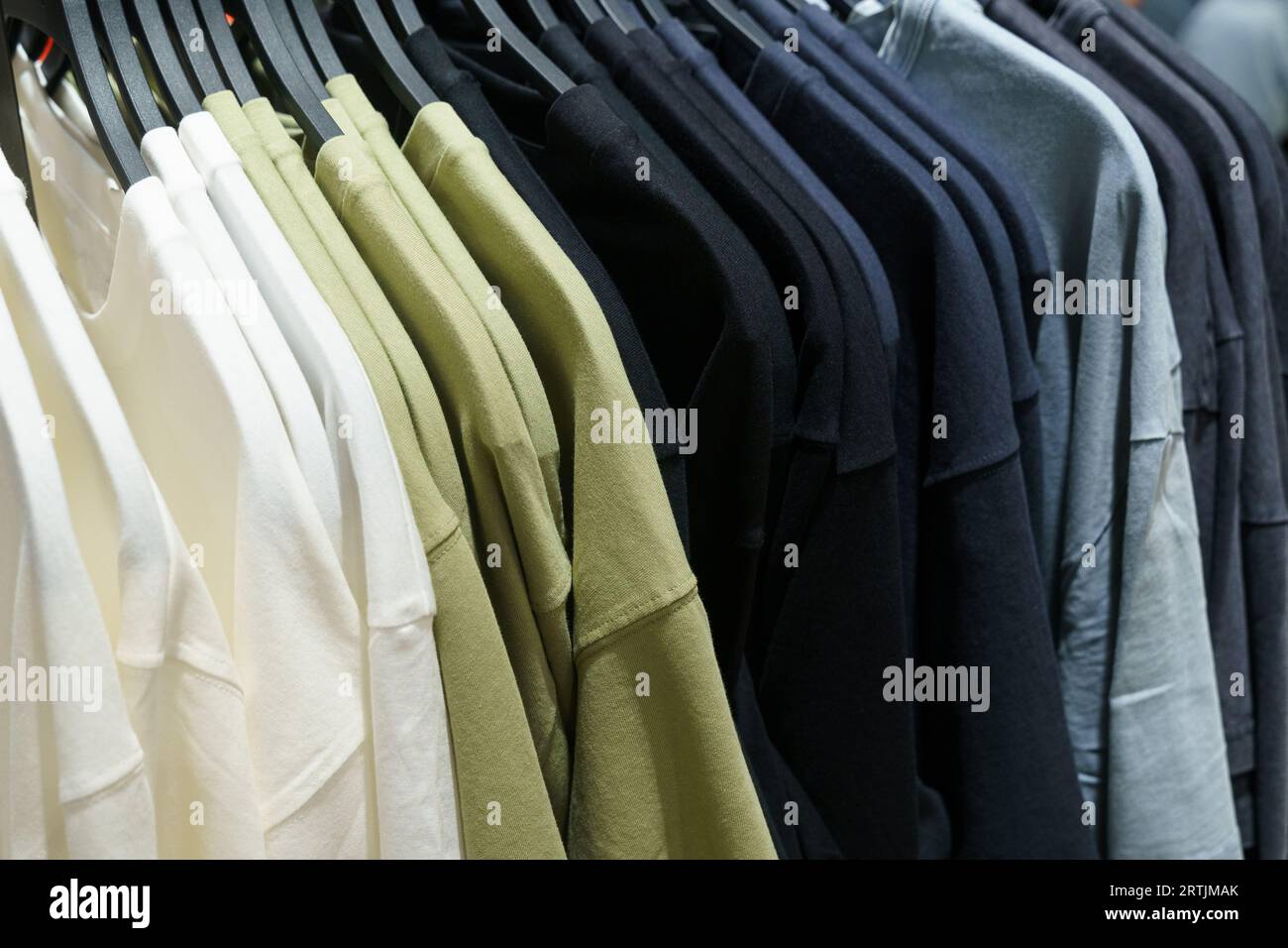 A collection of long sleeve t-shirts in pastel colors hanging on a ...