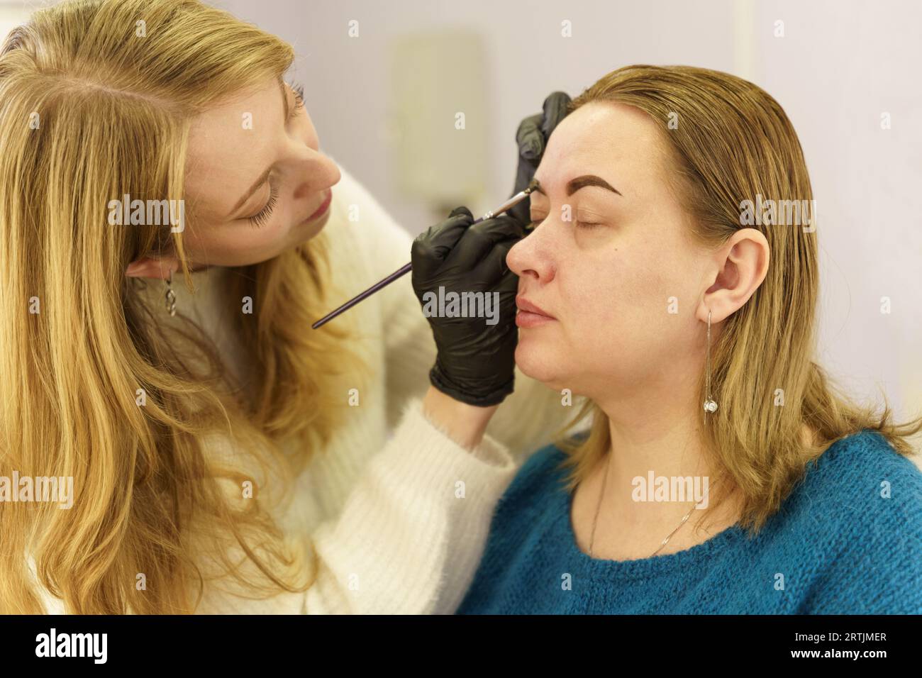 The master draws the shape of the eyebrows with white paint before ...