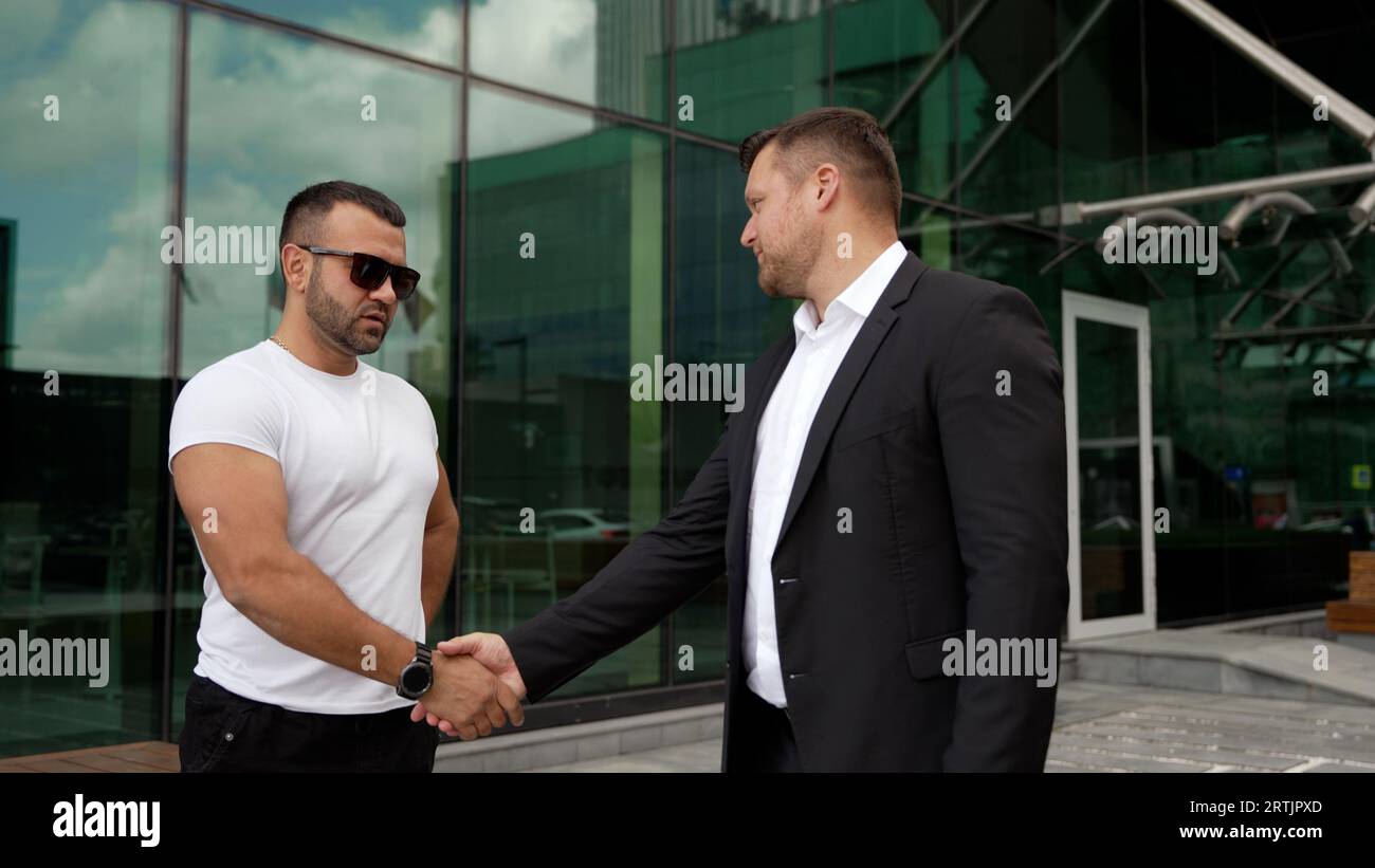Business concept. Male strong handshake. A businessman in a suit and an ...