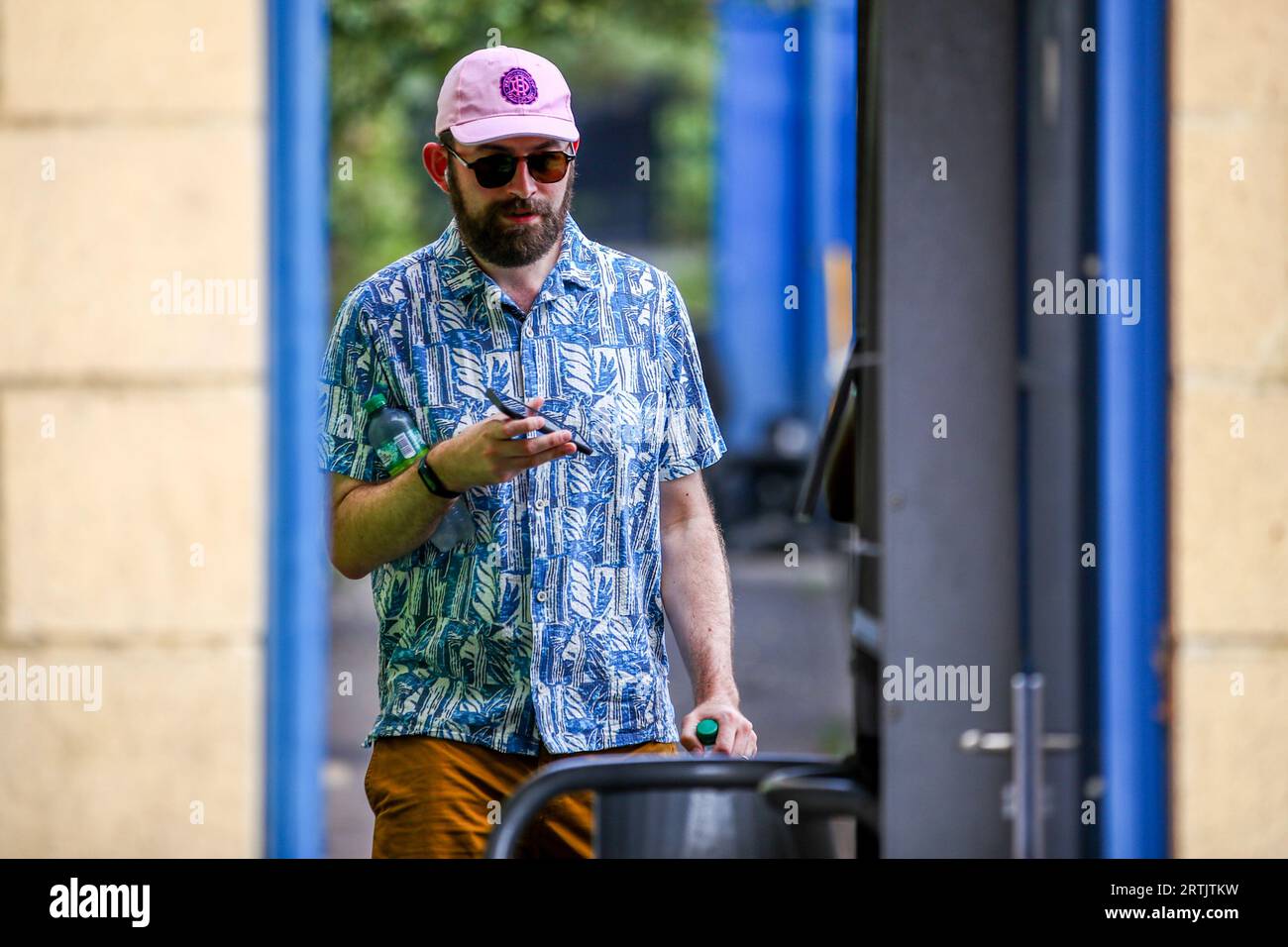 Football fan wearing pink Dulwich Hamlet cap arrives at turnstiles with ...