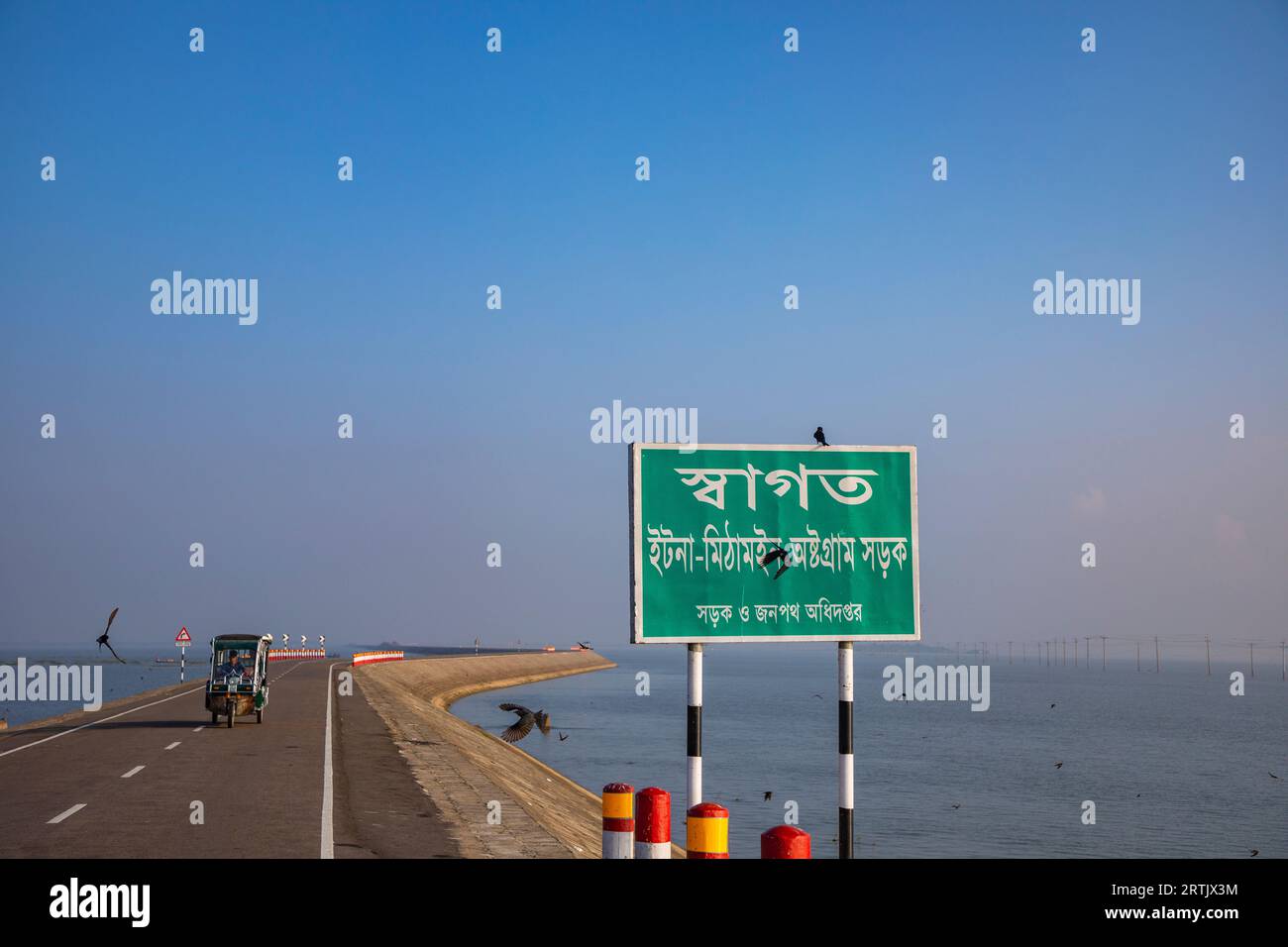 Itna-Mithamoin-Austagram all-weather road goes straight through a vast haor area in parallel ...