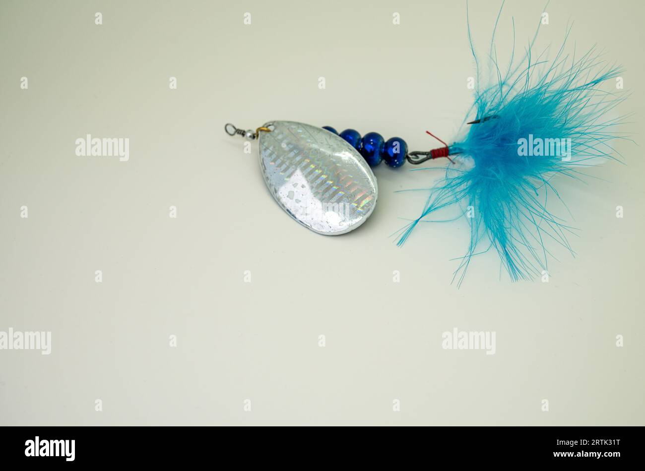 silver spinner with a blue fluffy hook on white background Stock Photo ...