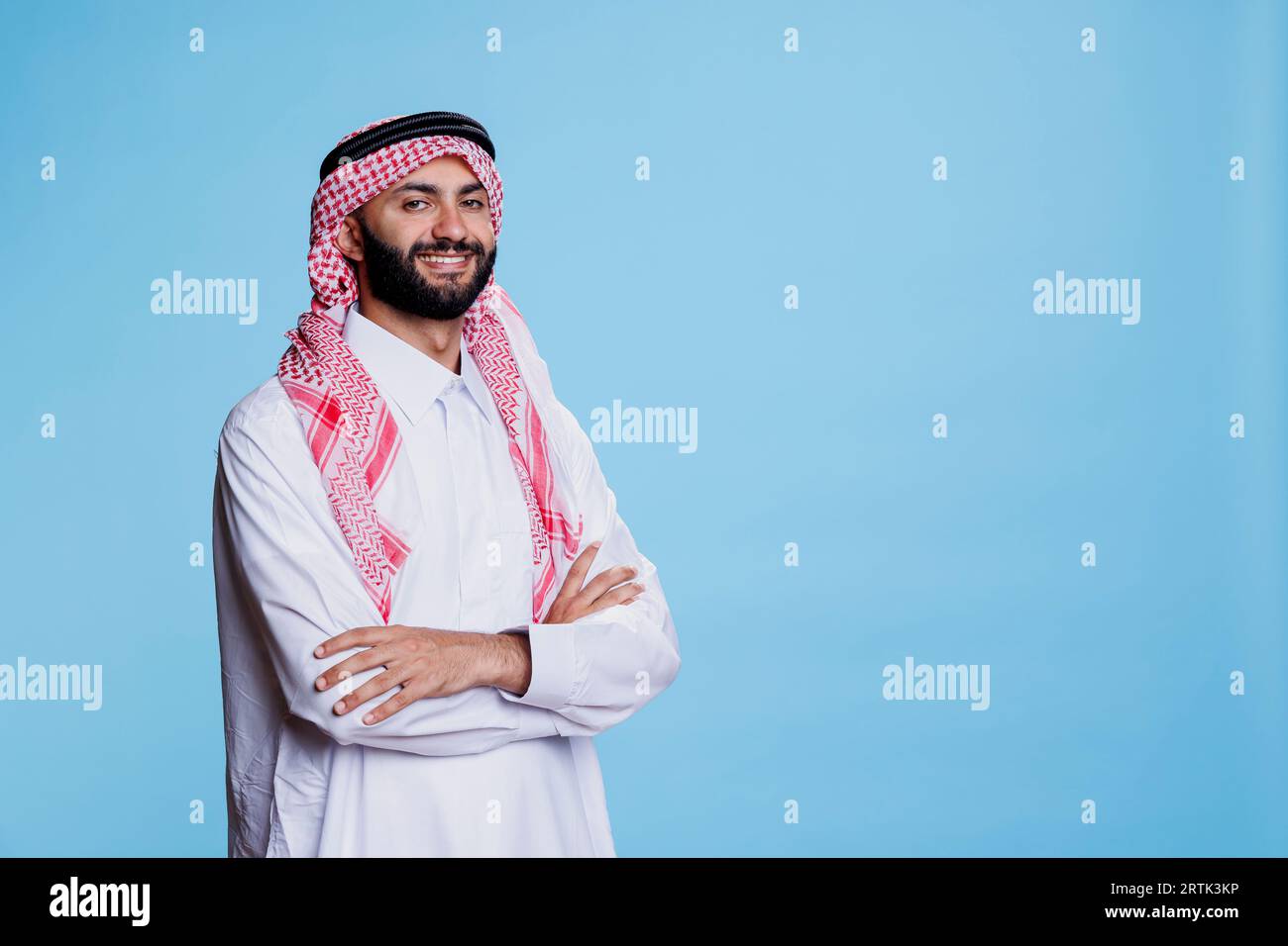 Smiling muslim man in islamic traditional clothes robe standing with ...