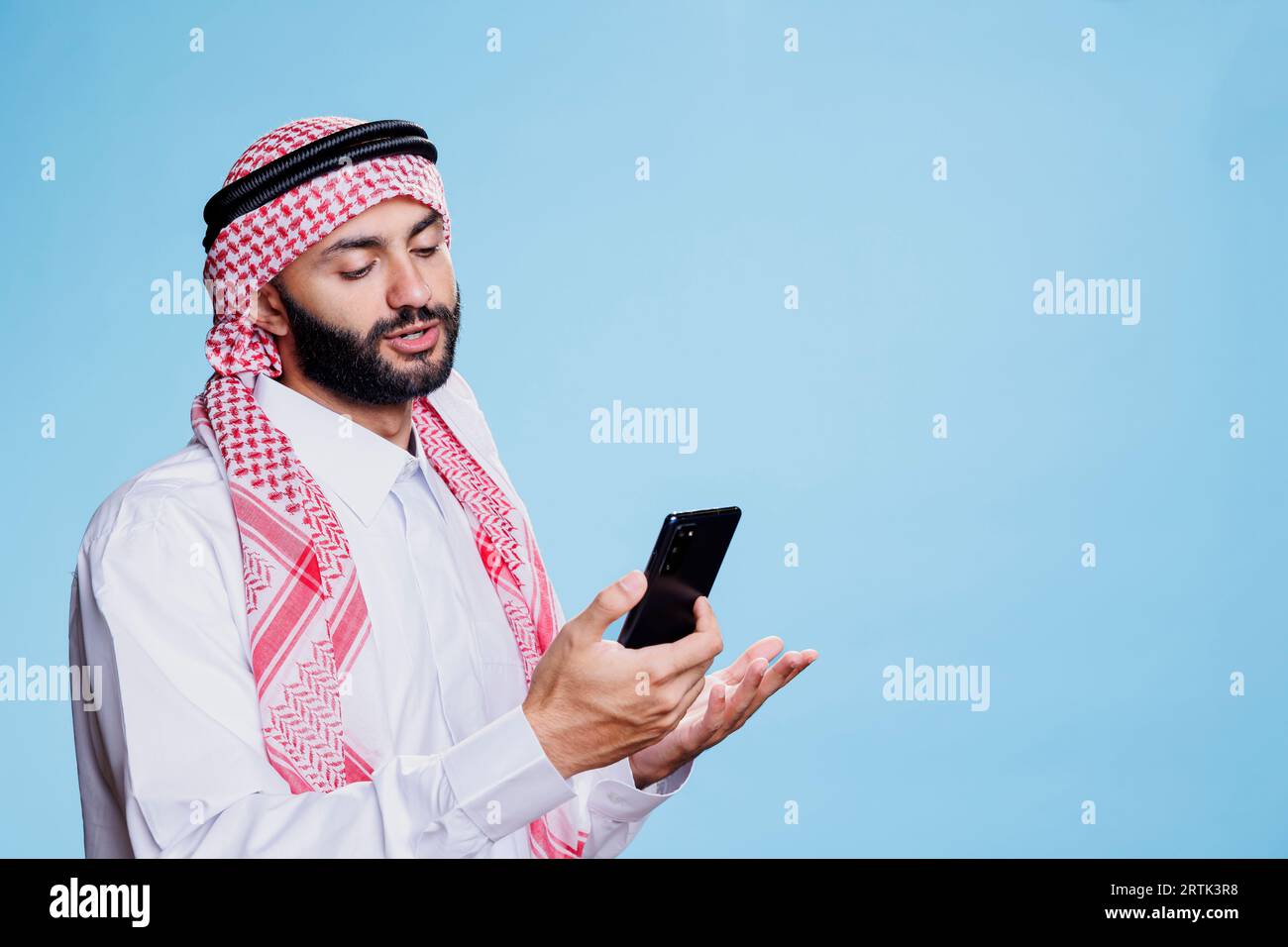 Muslim man dressed in traditional attire engaging in video chat on ...