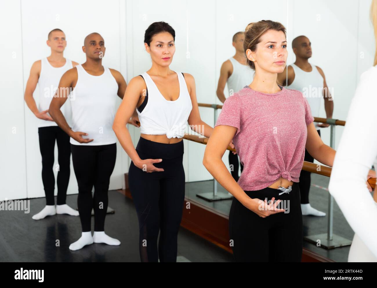 Group of people doing ballet exercises using barre in gym Stock Photo ...