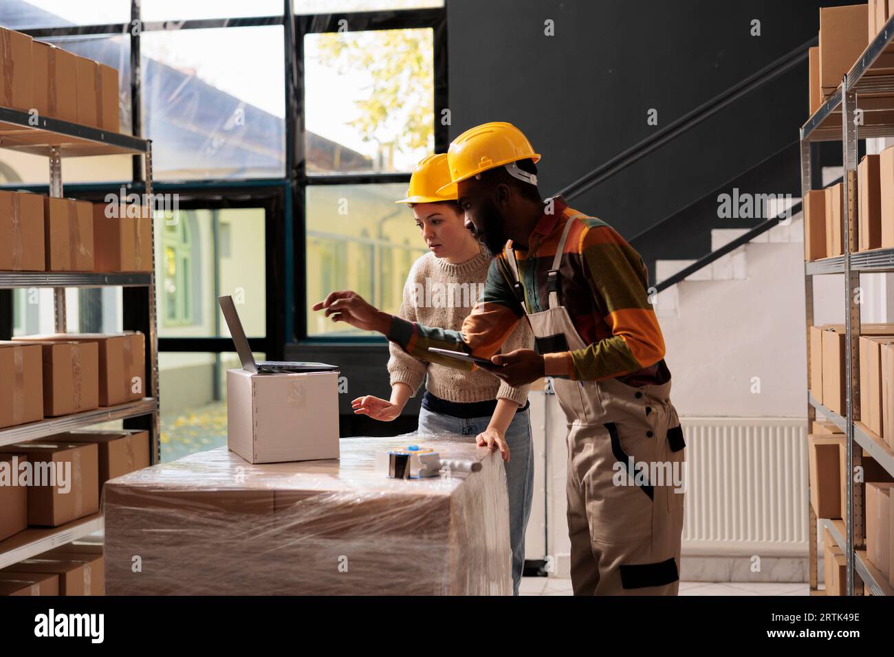 Stockroom team preparing customers orders using cardboard boxes ...
