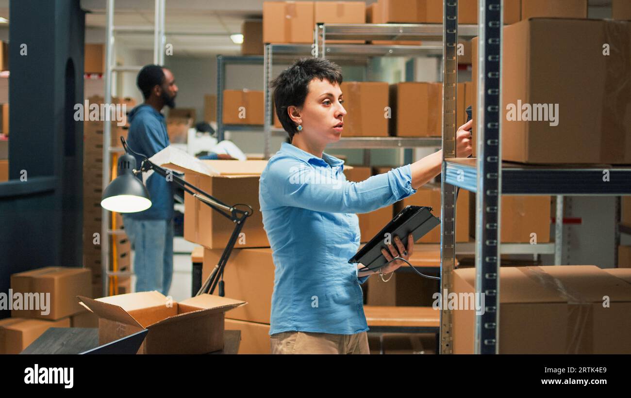 Female employee using scanner and tablet to do stock inventory ...