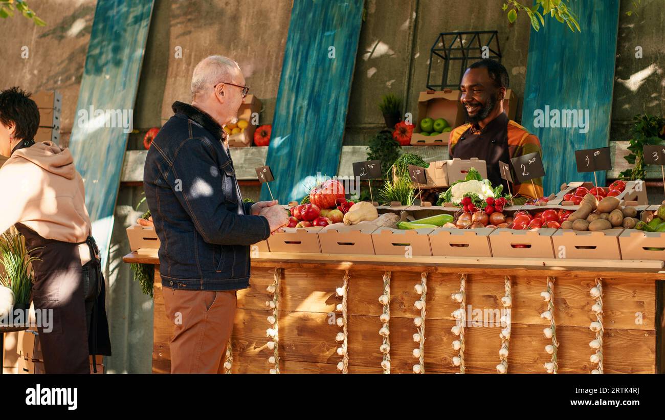 Happy business owner selling bio organic apples to customer, standing ...