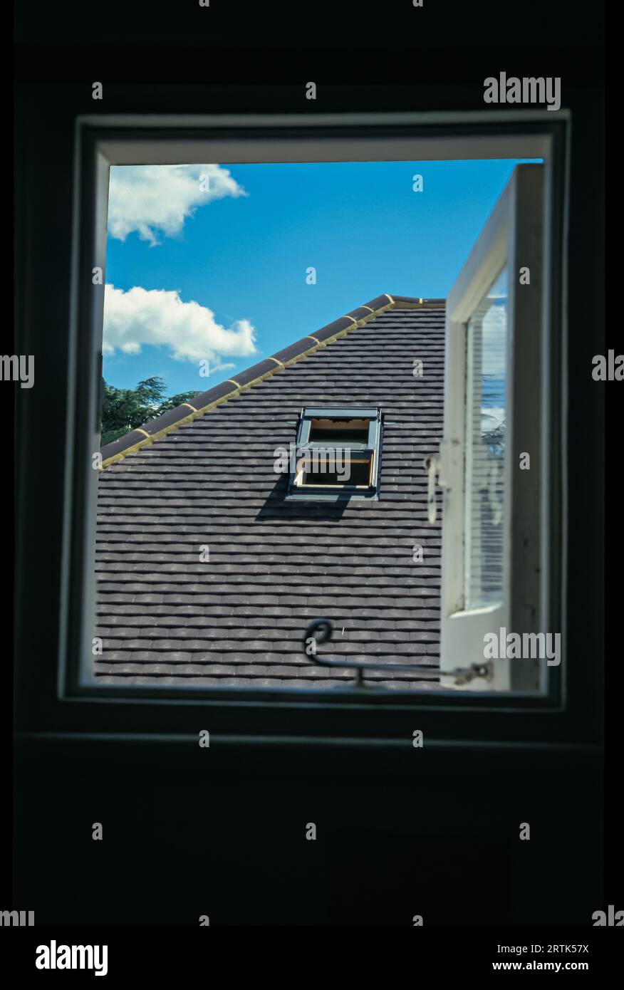Shingles rooftop with skylight viewed from a window frame Stock Photo ...