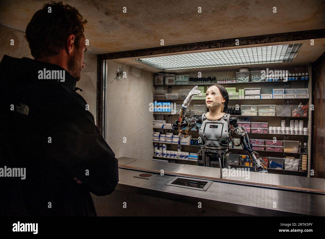 A man is seen looking at the robot talking about happiness. In his work, 'Happiness' theater ...