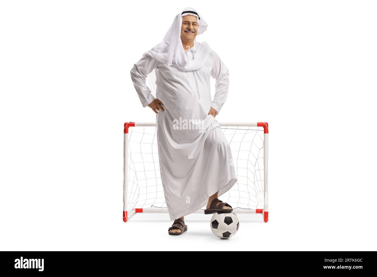 Mature arab man in a thobe with a soccer ball standing in front of a ...