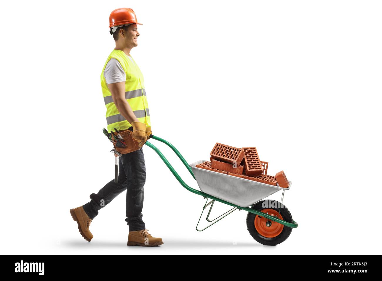 Construction worker pushing a wheelbarrow with bricks isolated on white ...