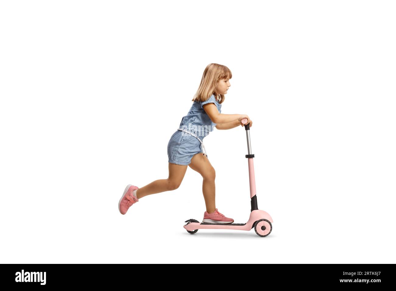 Full length profile shot of a girl riding a pink scooter isolated on ...
