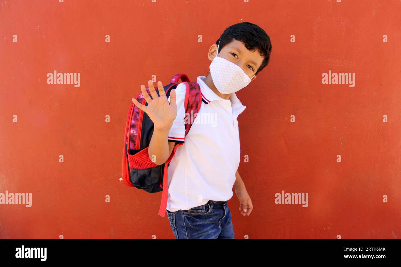 Latino boy with uniform shirt, backpack and mask back to school happy ...