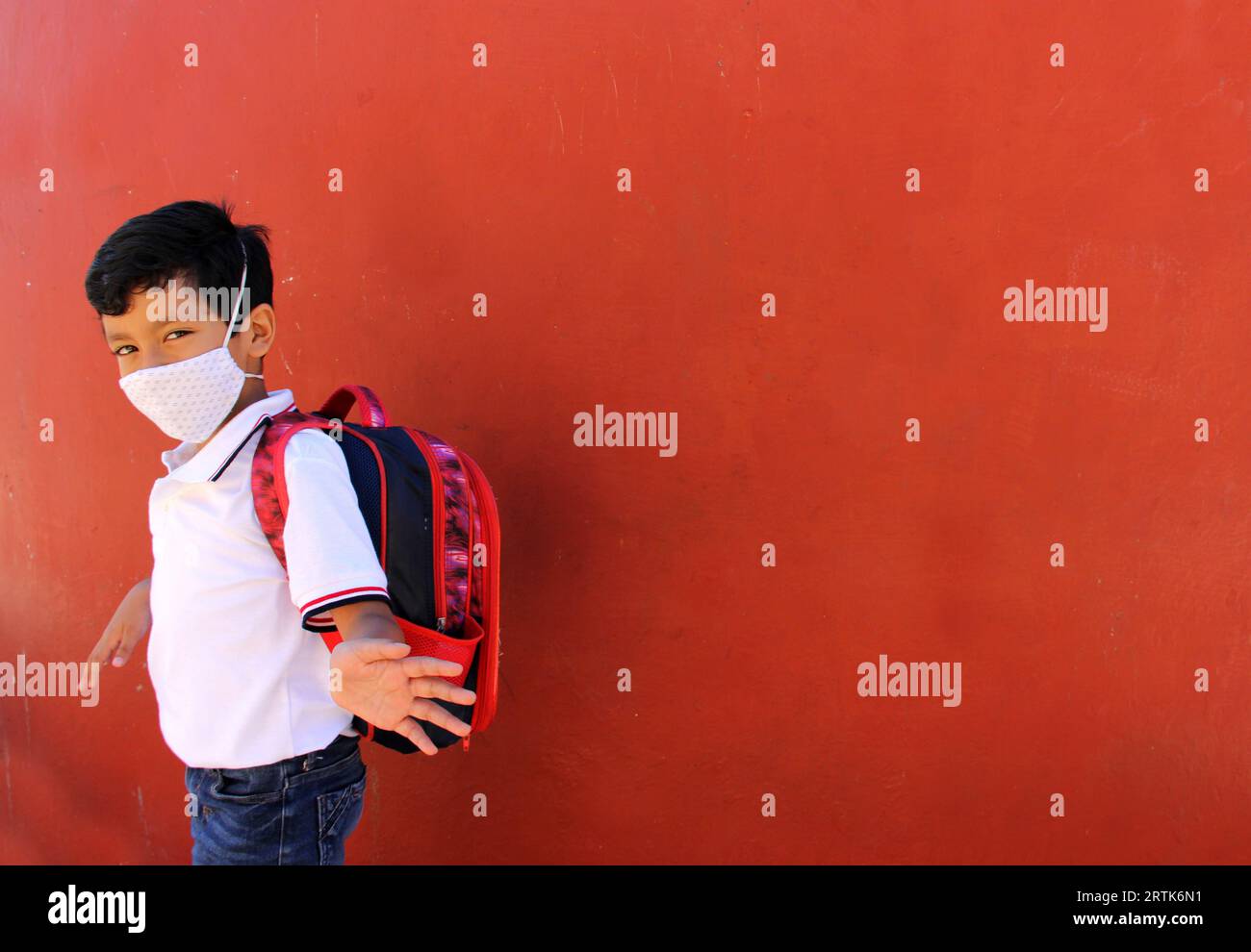 Latino boy with uniform shirt, backpack and mask back to school happy ...