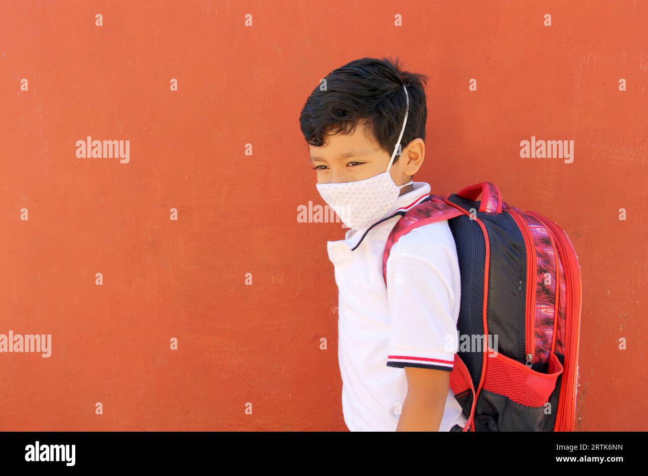 Latino boy with uniform shirt, backpack and mask back to school happy ...