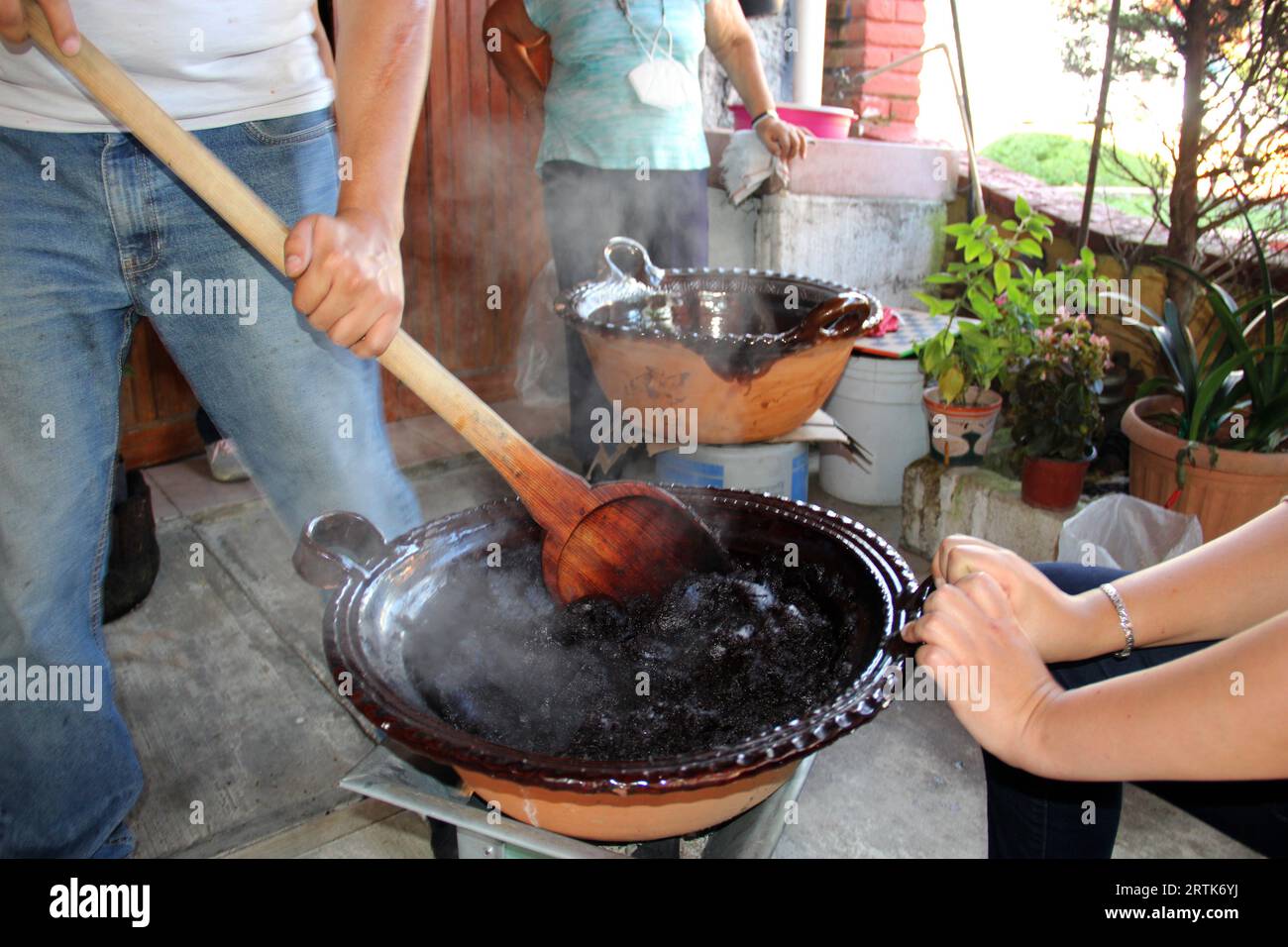 Preparation of red mole, a typical Mexican dish in a clay pot with a ...