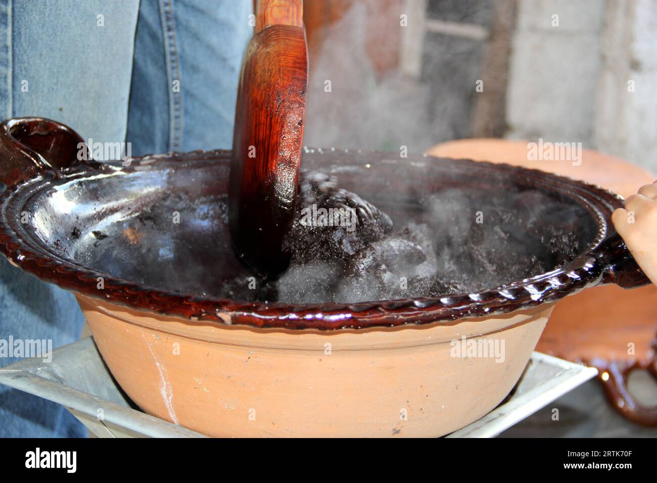 Preparation of red mole, a typical Mexican dish in a clay pot with a ...