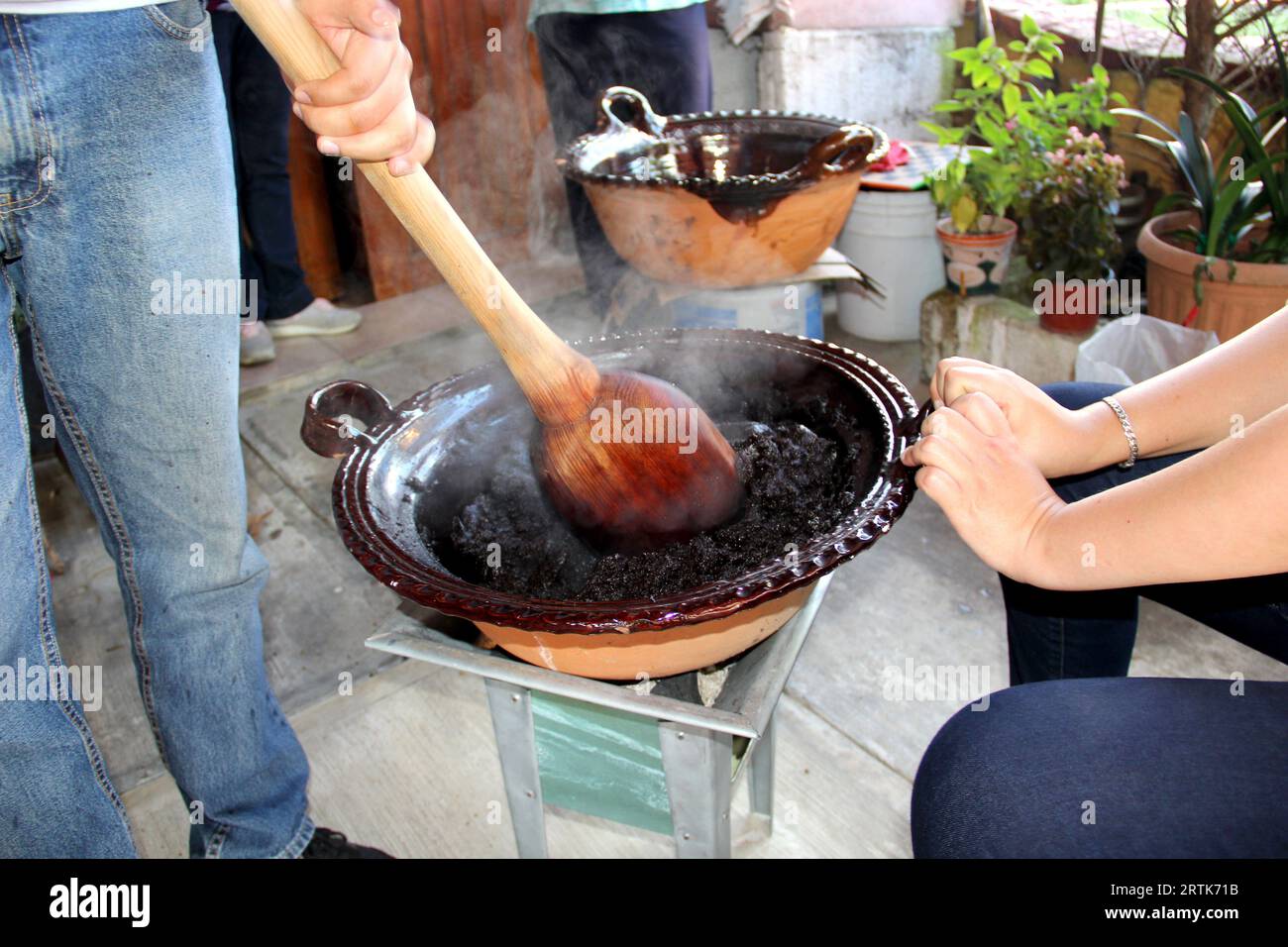 Preparation of red mole, a typical Mexican dish in a clay pot with a ...