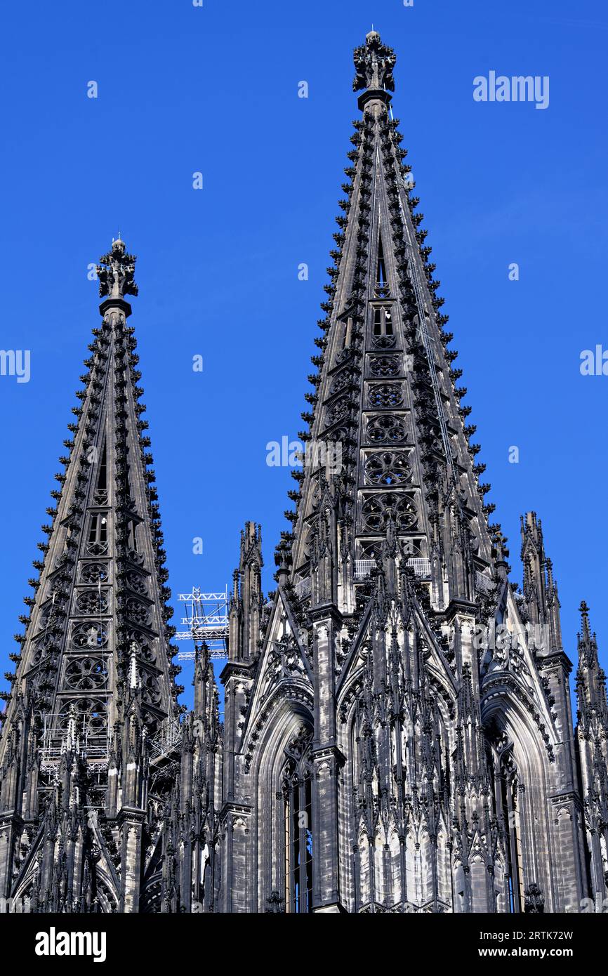 details of the double spires of cologne cathedral against a clear blue ...
