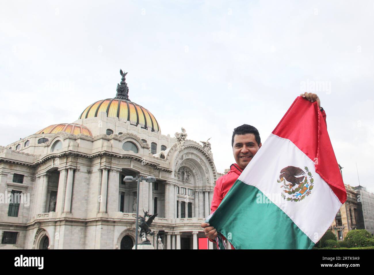 Dark-skinned Latino adult man shows the flag of Mexico proud of his ...